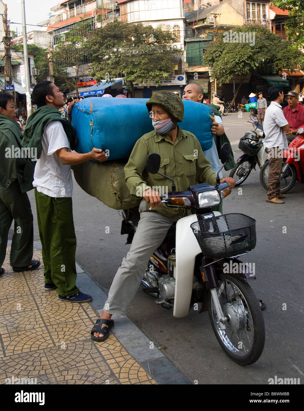 Man with overloaded motor bike carrying merchandise, Dong Xuan market ...