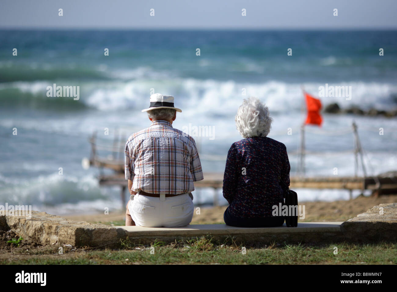 Elderly couple sitting on a stone wharf on the Sea Stock Photo - Alamy