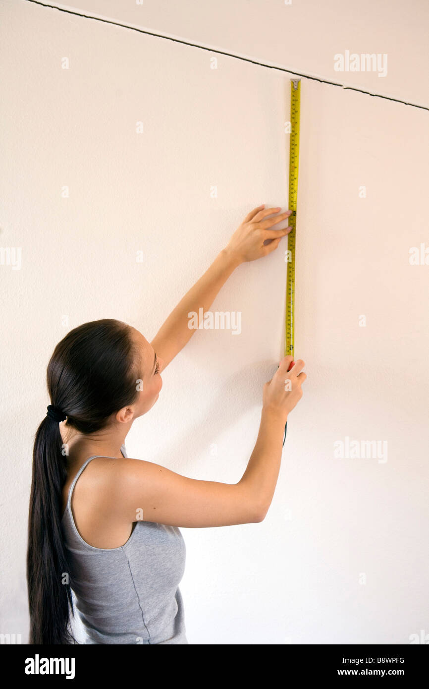 woman measuring a wall Stock Photo - Alamy