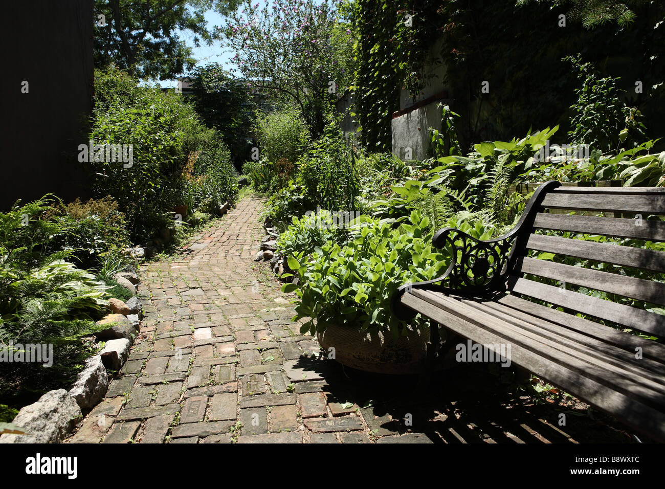 A park bench and path in a public garden Stock Photo - Alamy