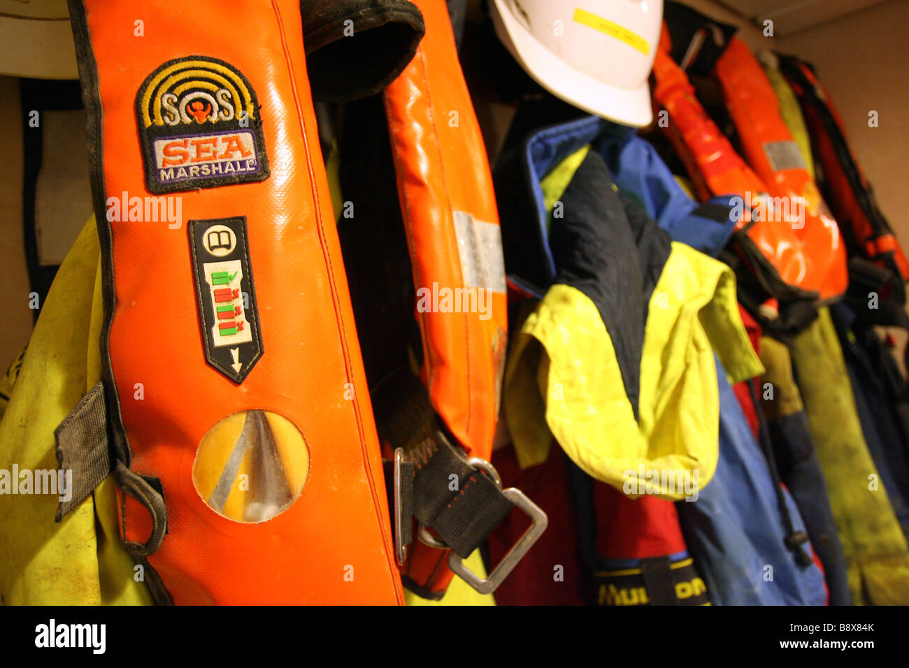 Lifejackets and life preservers and fishing gear hanging up inside a ...