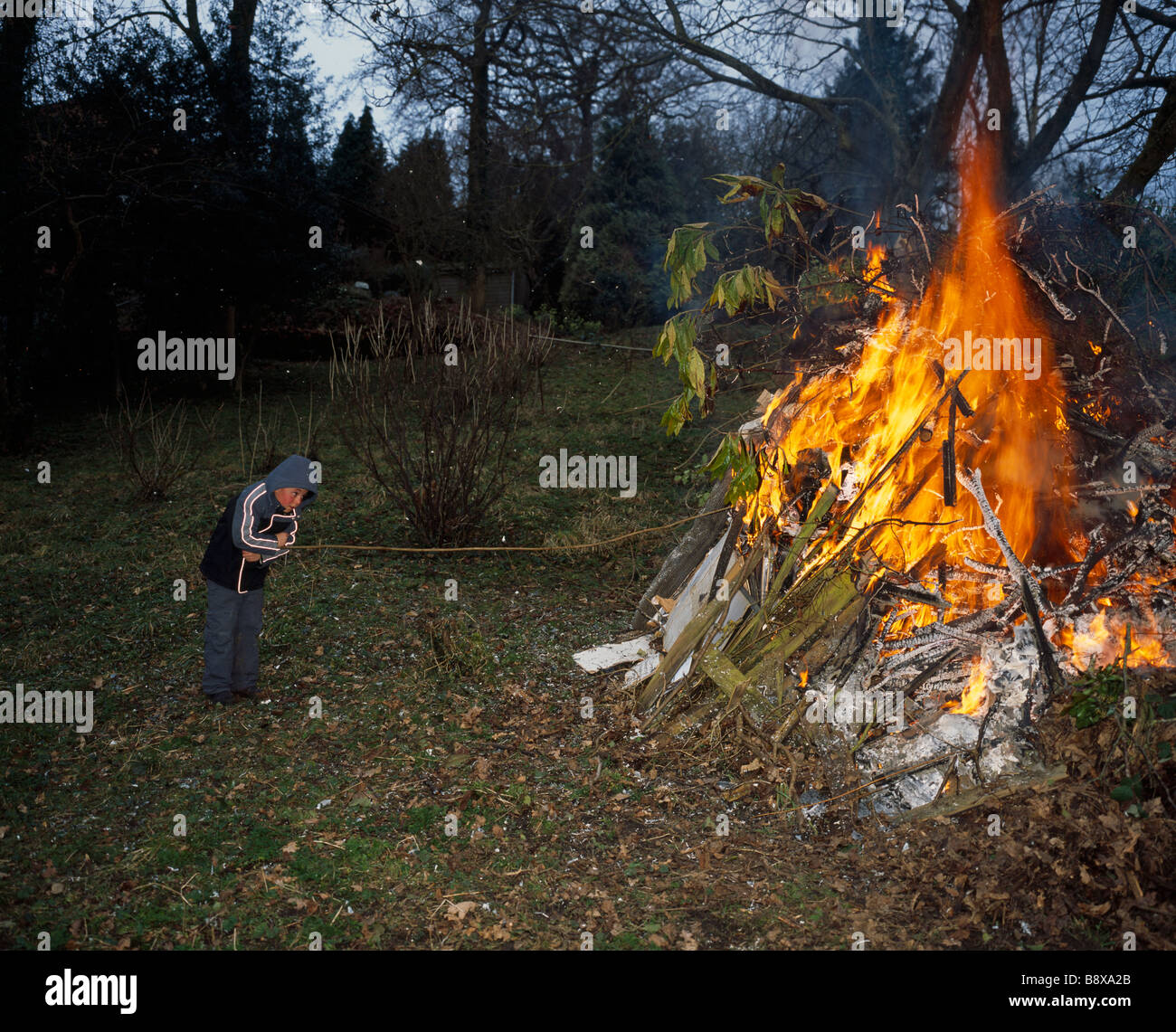 Boy tending a bonfire Stock Photo - Alamy