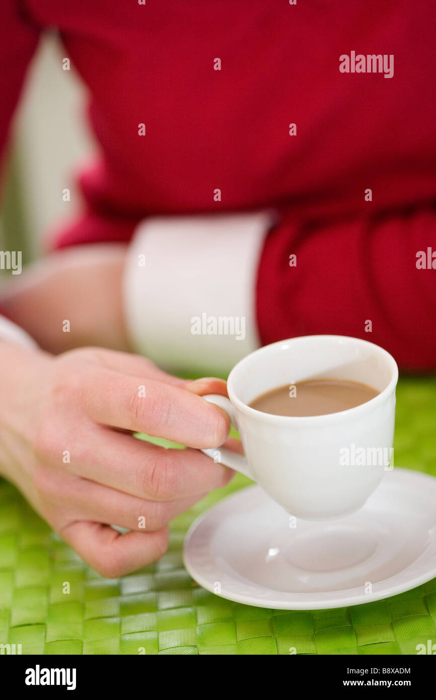 Hand lifting up a small cup of coffee Stock Photo - Alamy