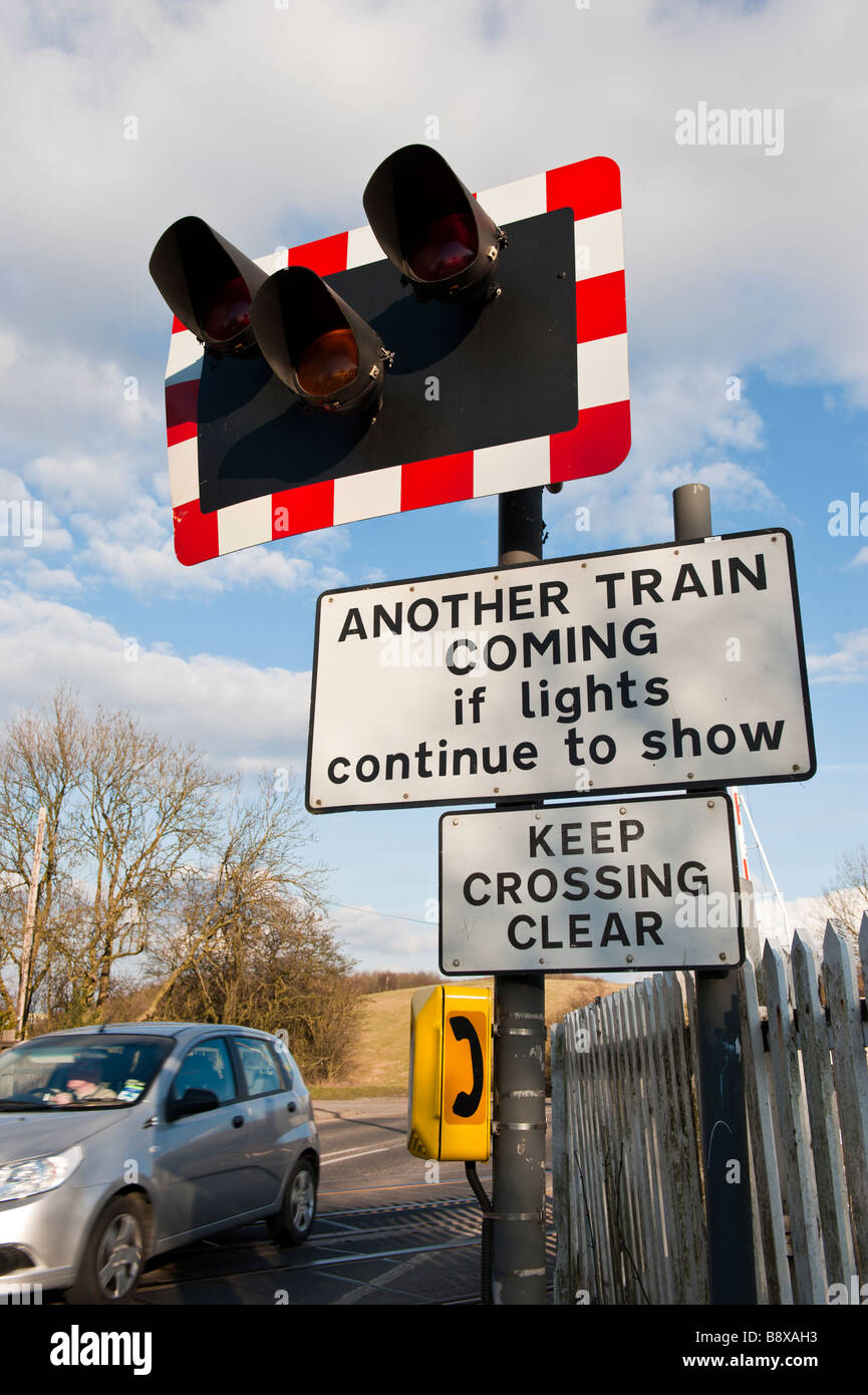 Signage at a train railway crossing. A car is passing over the crossing ...