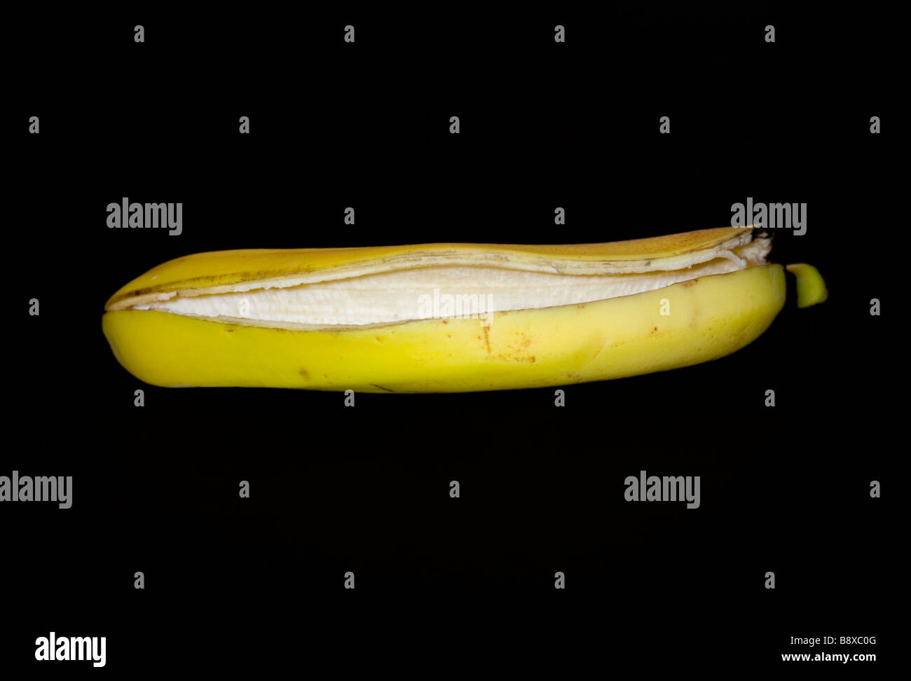 Open banana peel on black background Stock Photo - Alamy