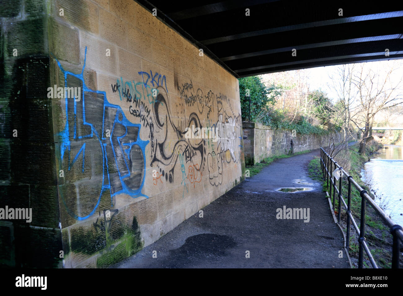 A wall under a bridge with graffiti Stock Photo - Alamy