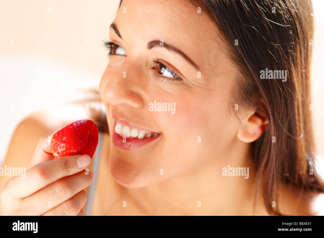 Woman eating a Strawberry Stock Photo - Alamy