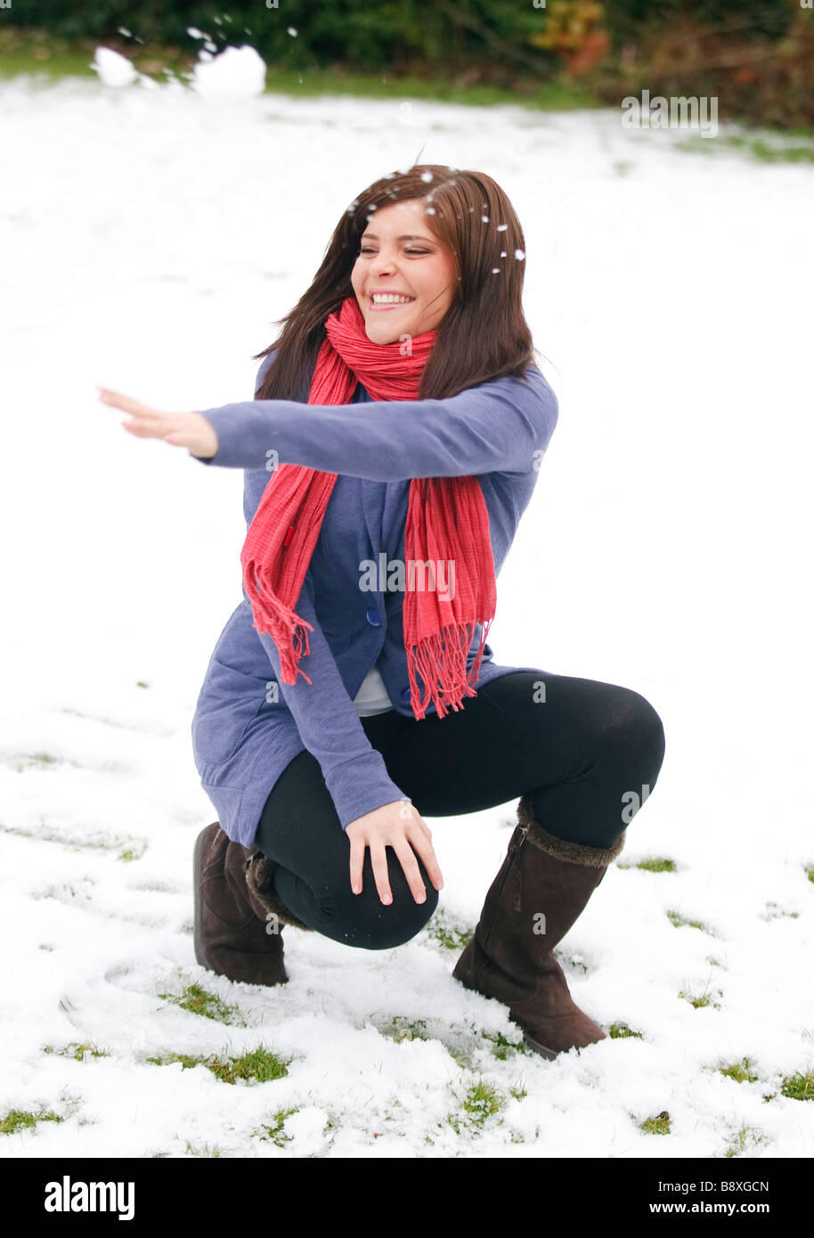 Girl throwing snowballs Stock Photo - Alamy