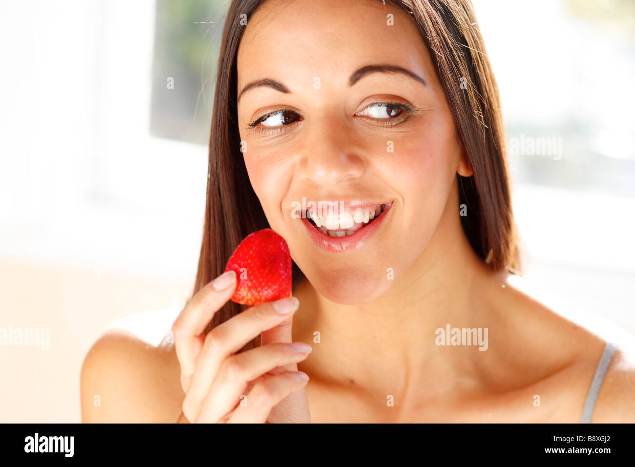 Woman eating a Strawberry Stock Photo - Alamy