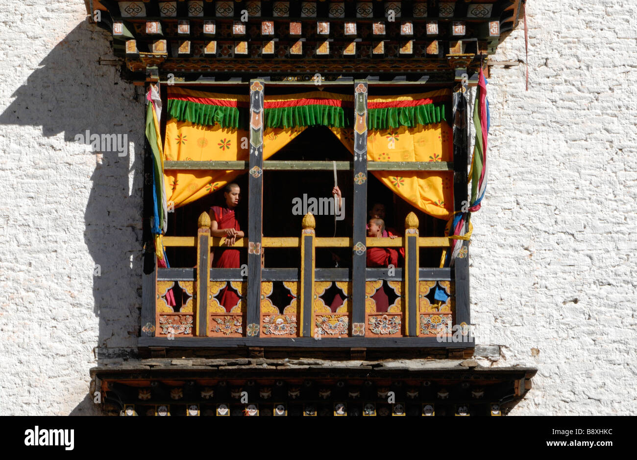 Two young buddhist monks watch dancers and musicians at the Trashigang ...