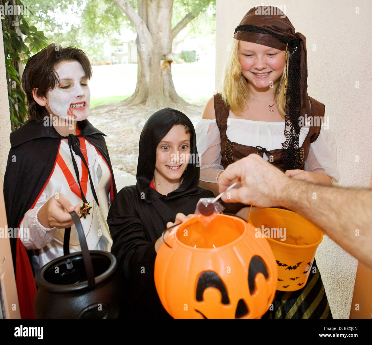 Adorable trick or treaters in the doorway waiting for candy Stock Photo ...