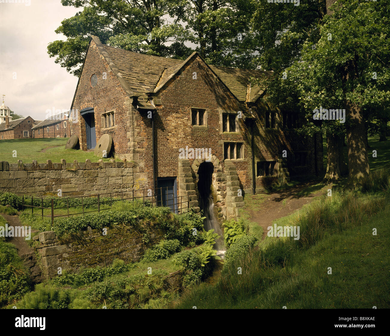 The brick built Watermill at Dunham Massey Two millstones lean against ...