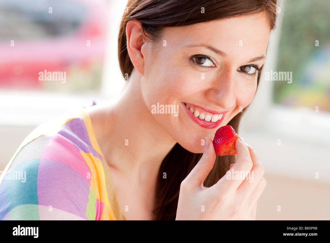 Woman eating a Strawberry Stock Photo - Alamy