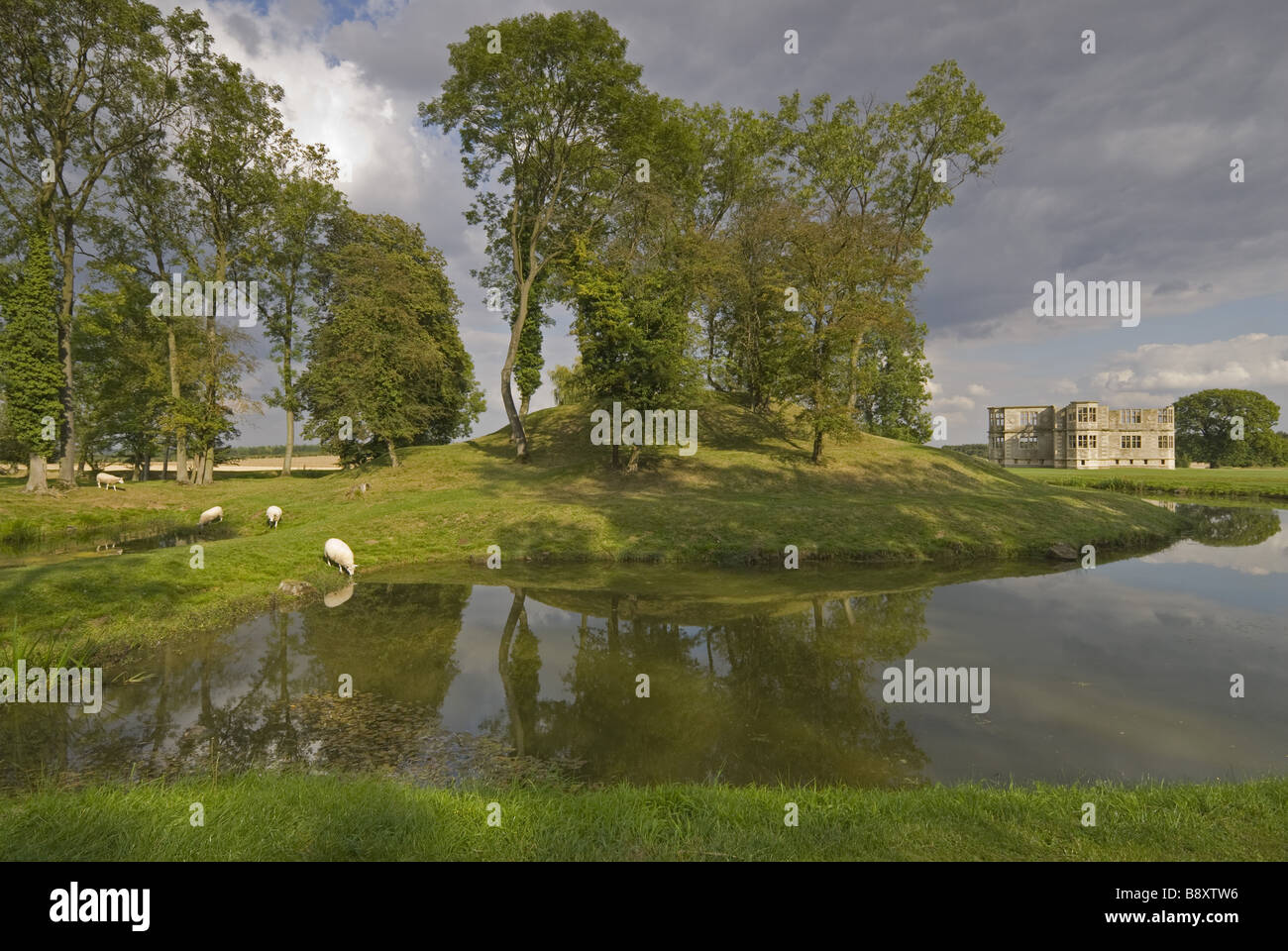 Sheep alongside the Water Garden with the building beyond at Lyveden ...