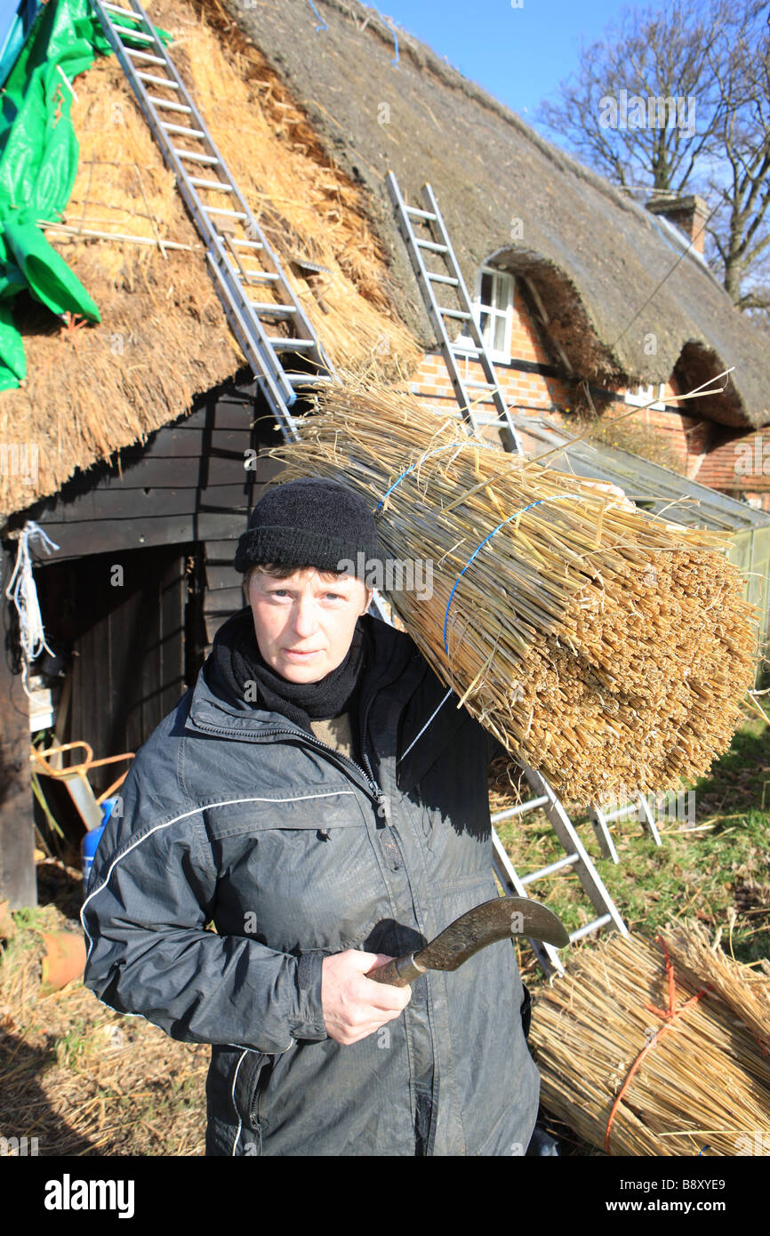 Kate Glover a master thatcher working on a roof near Newbury Stock ...