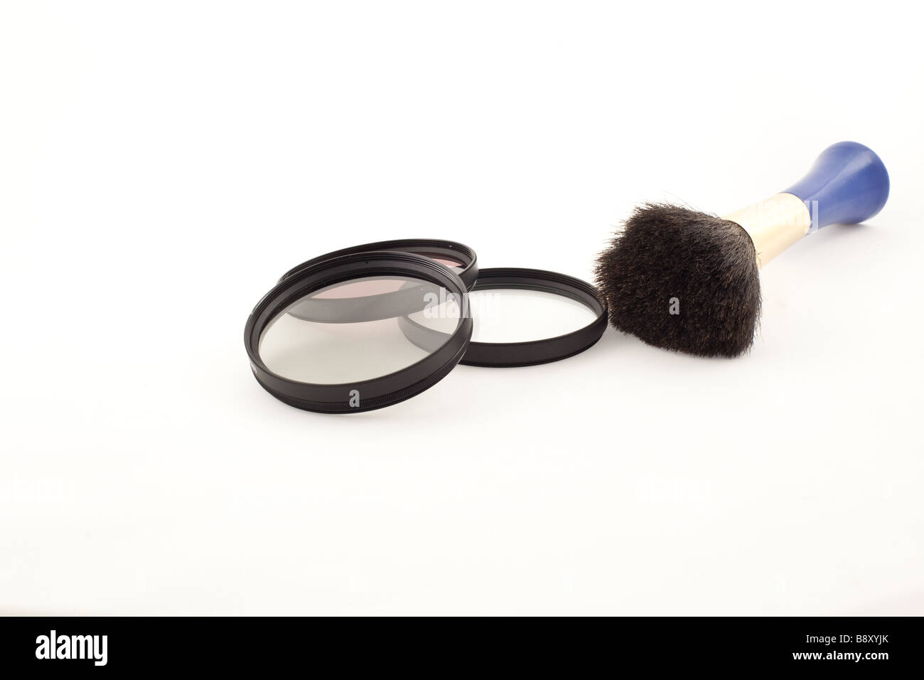 Three lens filters and brush with blue handle Stock Photo - Alamy