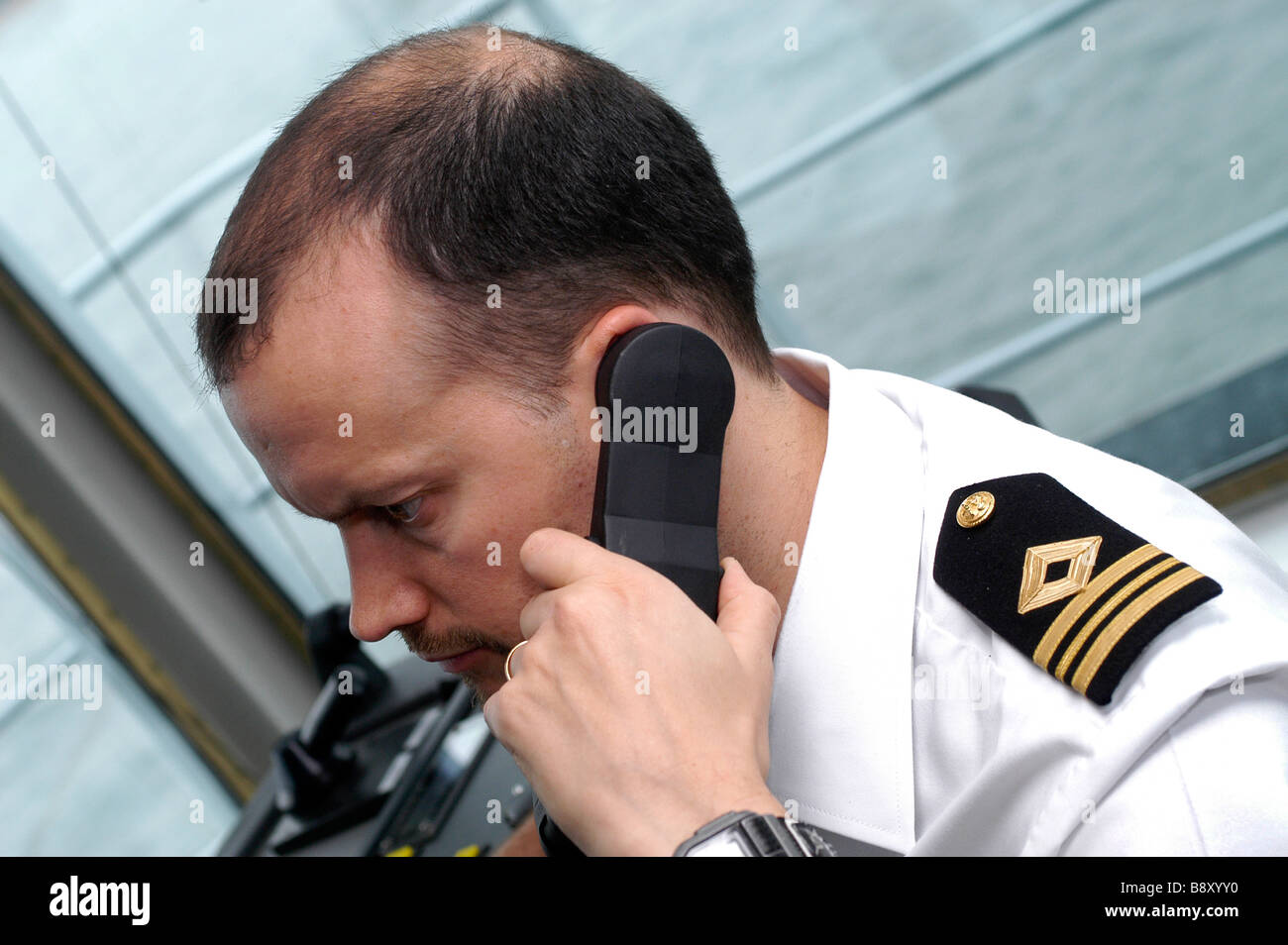 An officer of the Royal Fleet Auxiliary uses a radio telephone on the ...