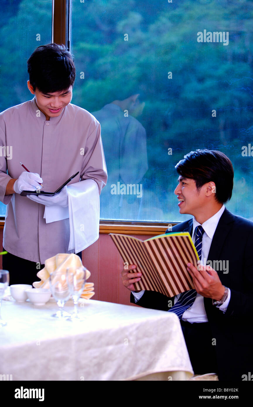 Young waiter serving for the customer and smiling together Stock Photo ...