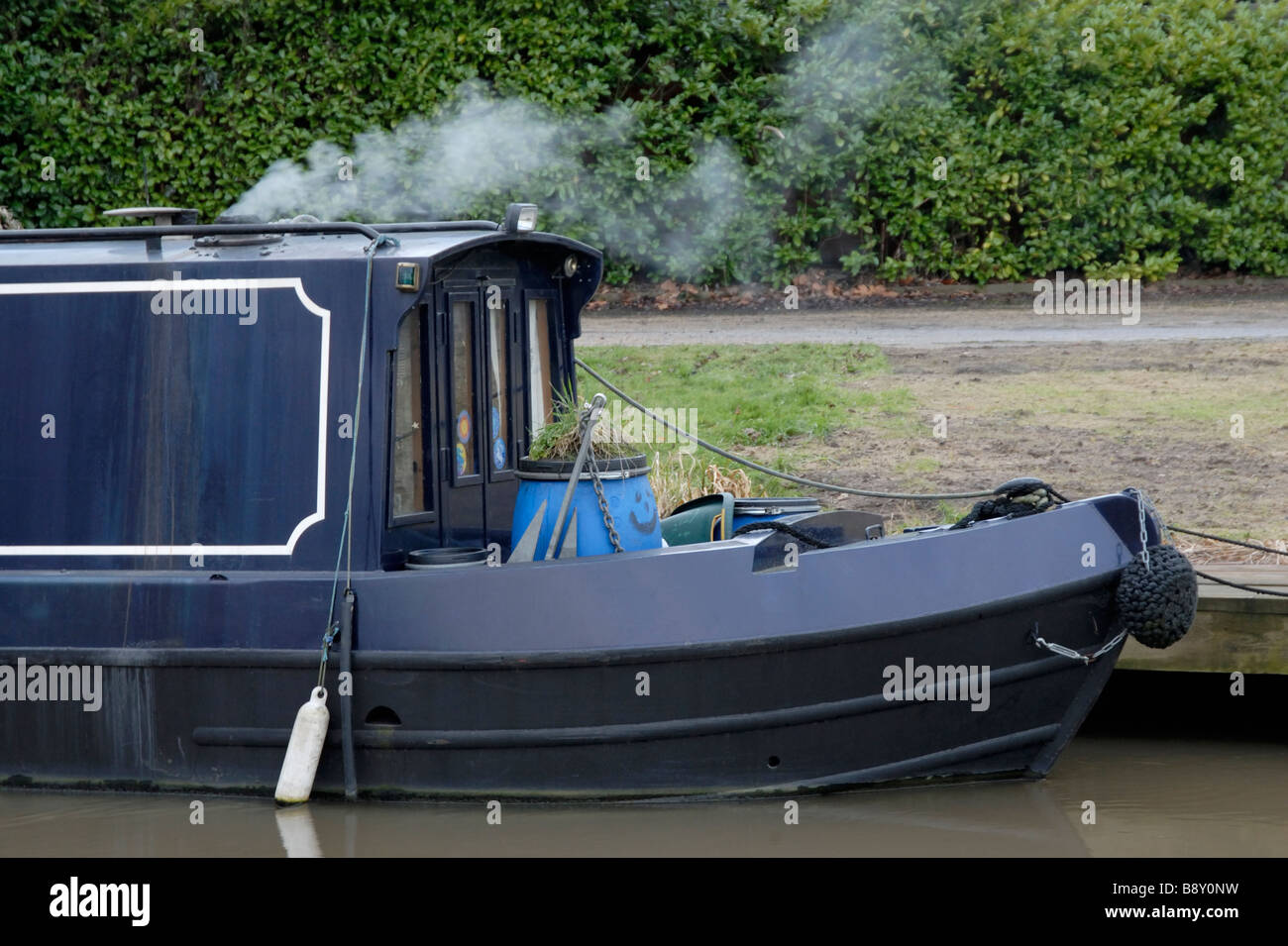 Smoke emerging from roof of live aboard narrowboat, Godalming Wharf ...