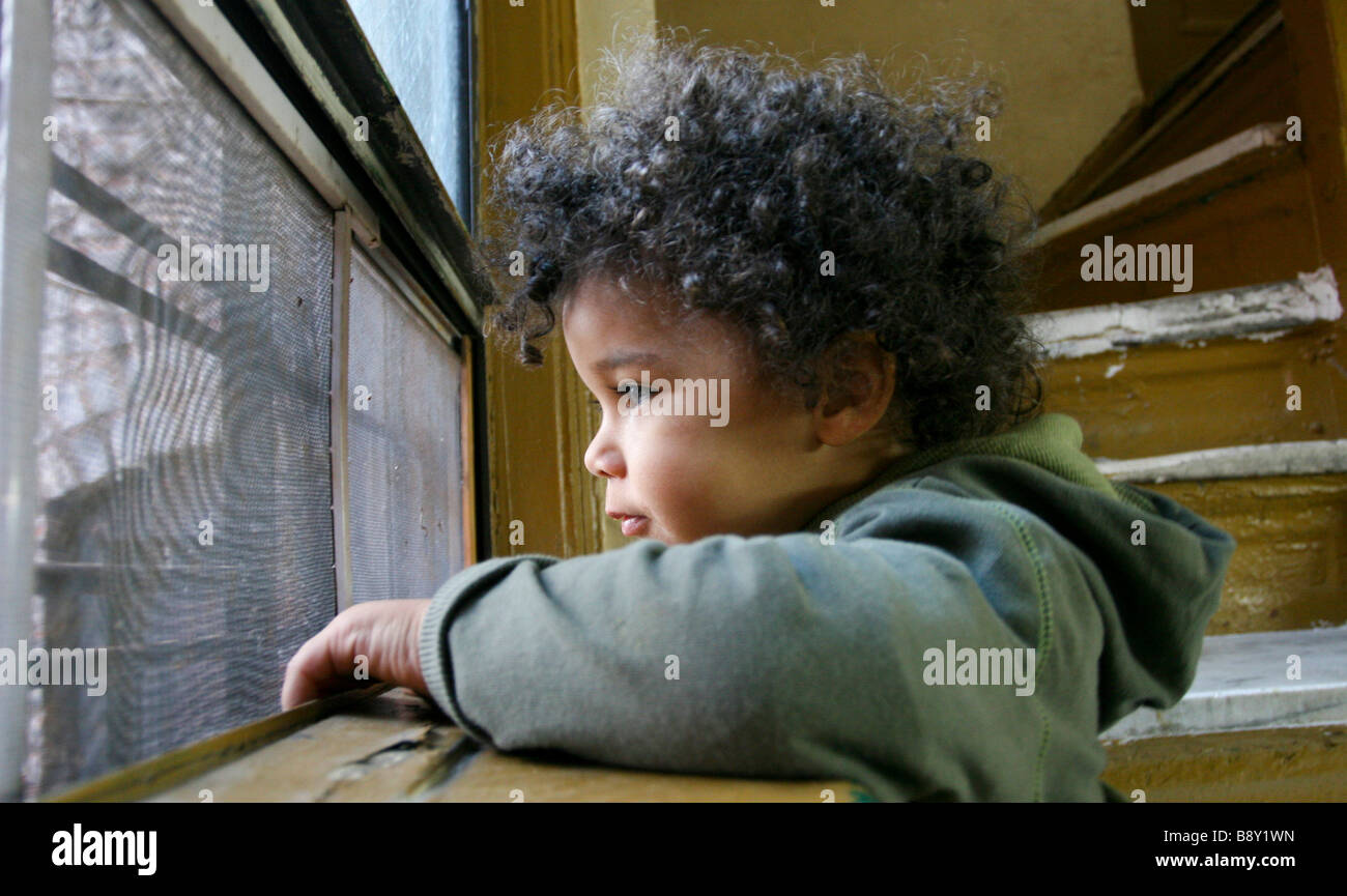 Boy looking out through a window Stock Photo - Alamy