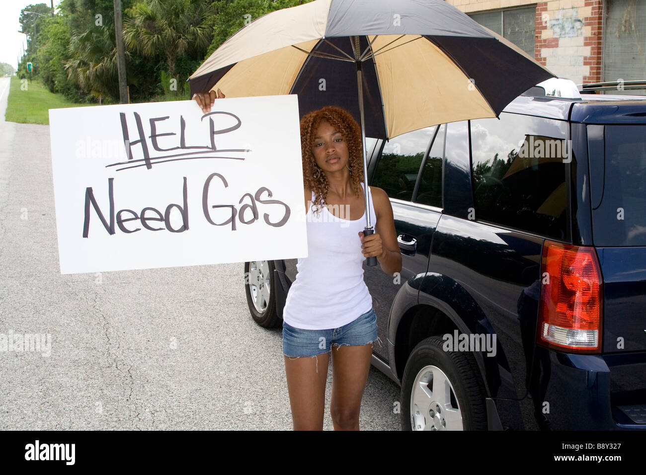 Young woman standing and holding a Help sign board Stock Photo - Alamy
