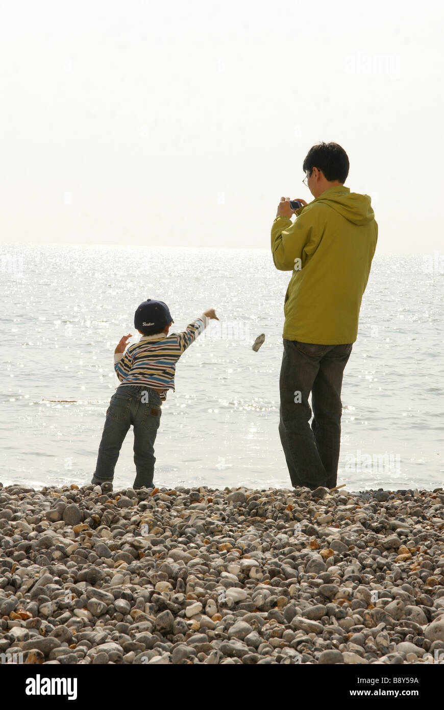 Boy throwing pebbles into the sea hi-res stock photography and images ...