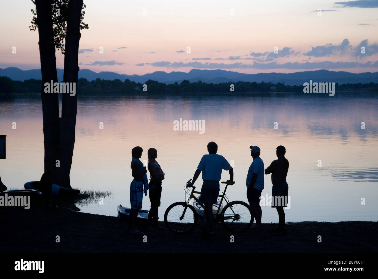 Five people standing at the lakeside Stock Photo - Alamy