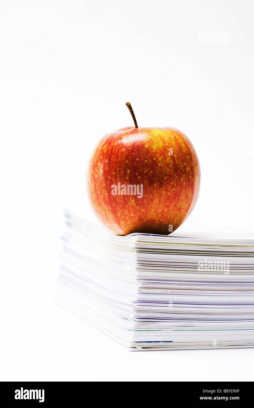 An apple on a stack of paper close-up Stock Photo - Alamy