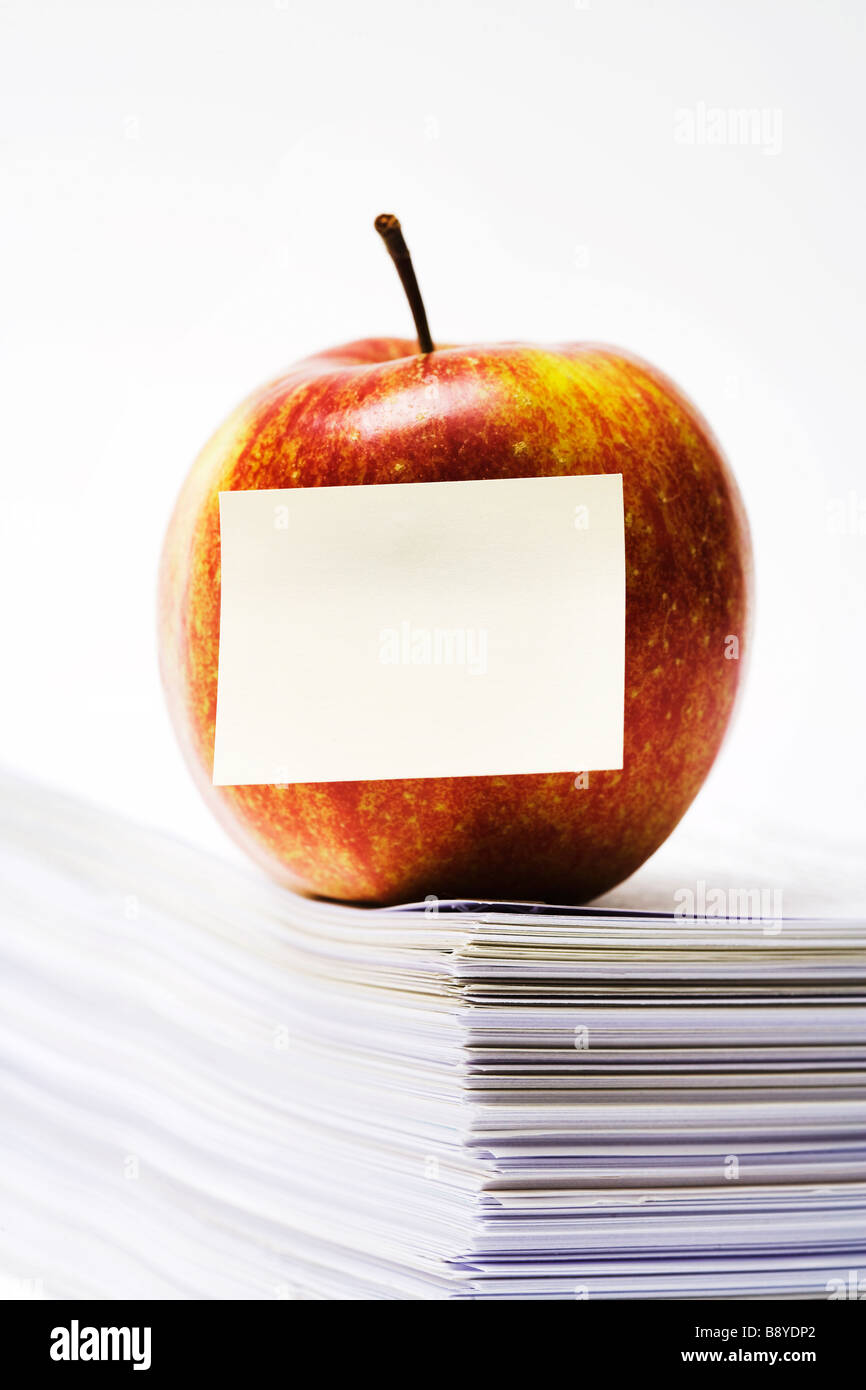 An apple on a stack of paper close-up Stock Photo - Alamy