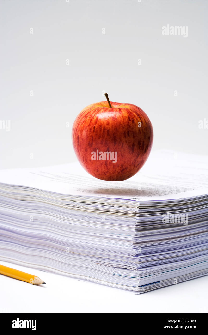 An apple on a stack of paper close-up Stock Photo - Alamy