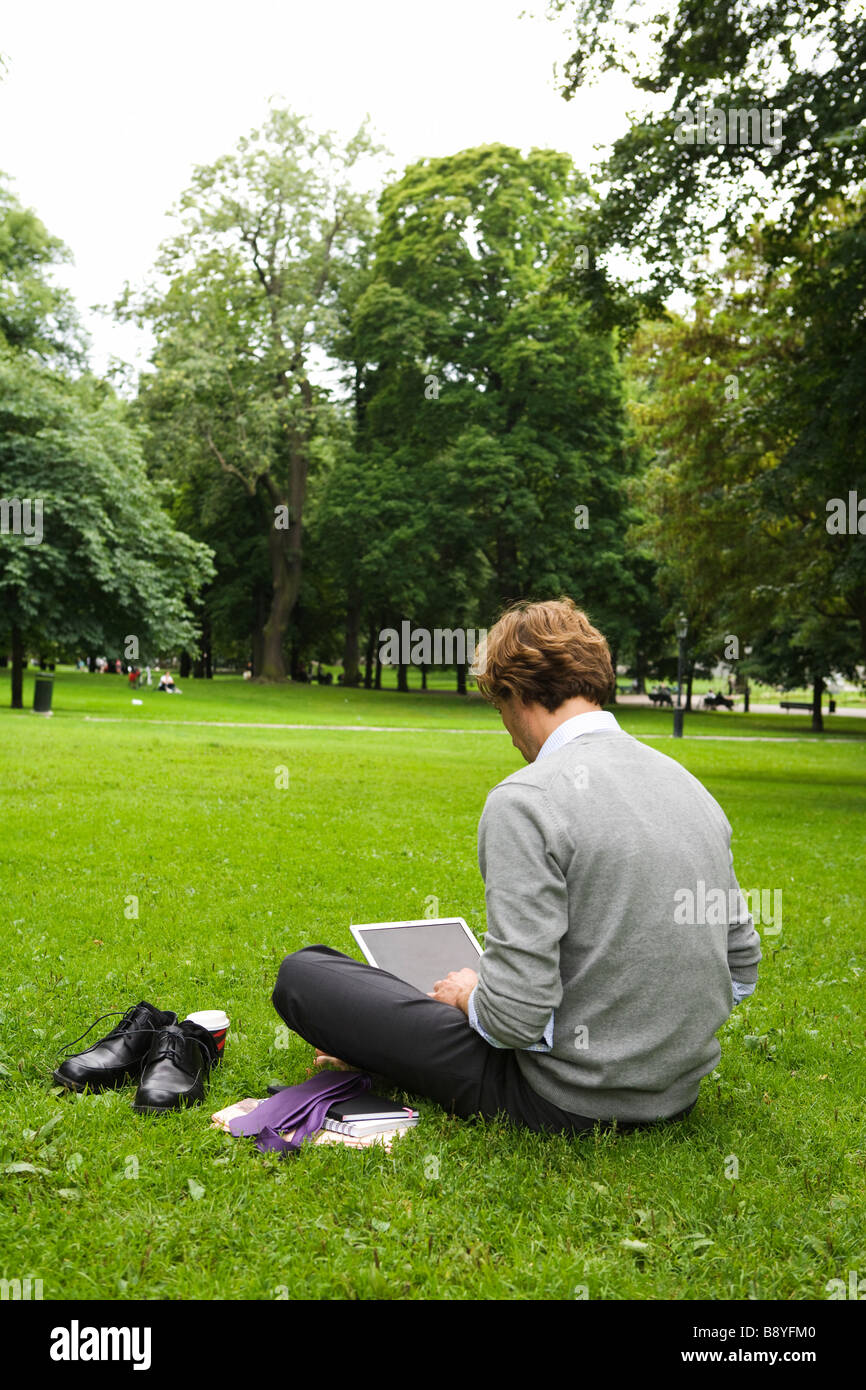 A man with a laptop in a park Sweden Stock Photo - Alamy