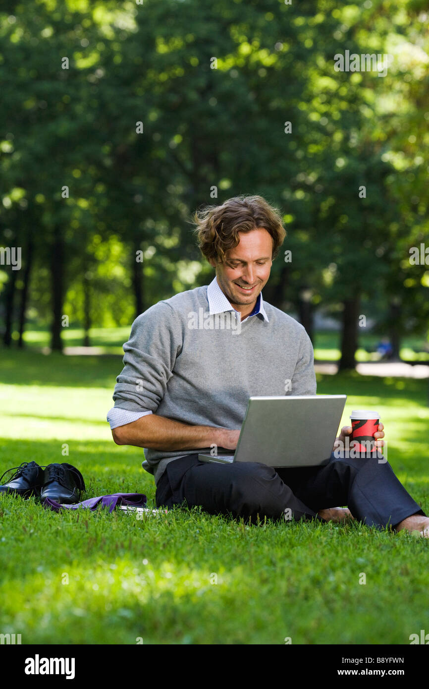 A man with a laptop in a park Sweden Stock Photo - Alamy