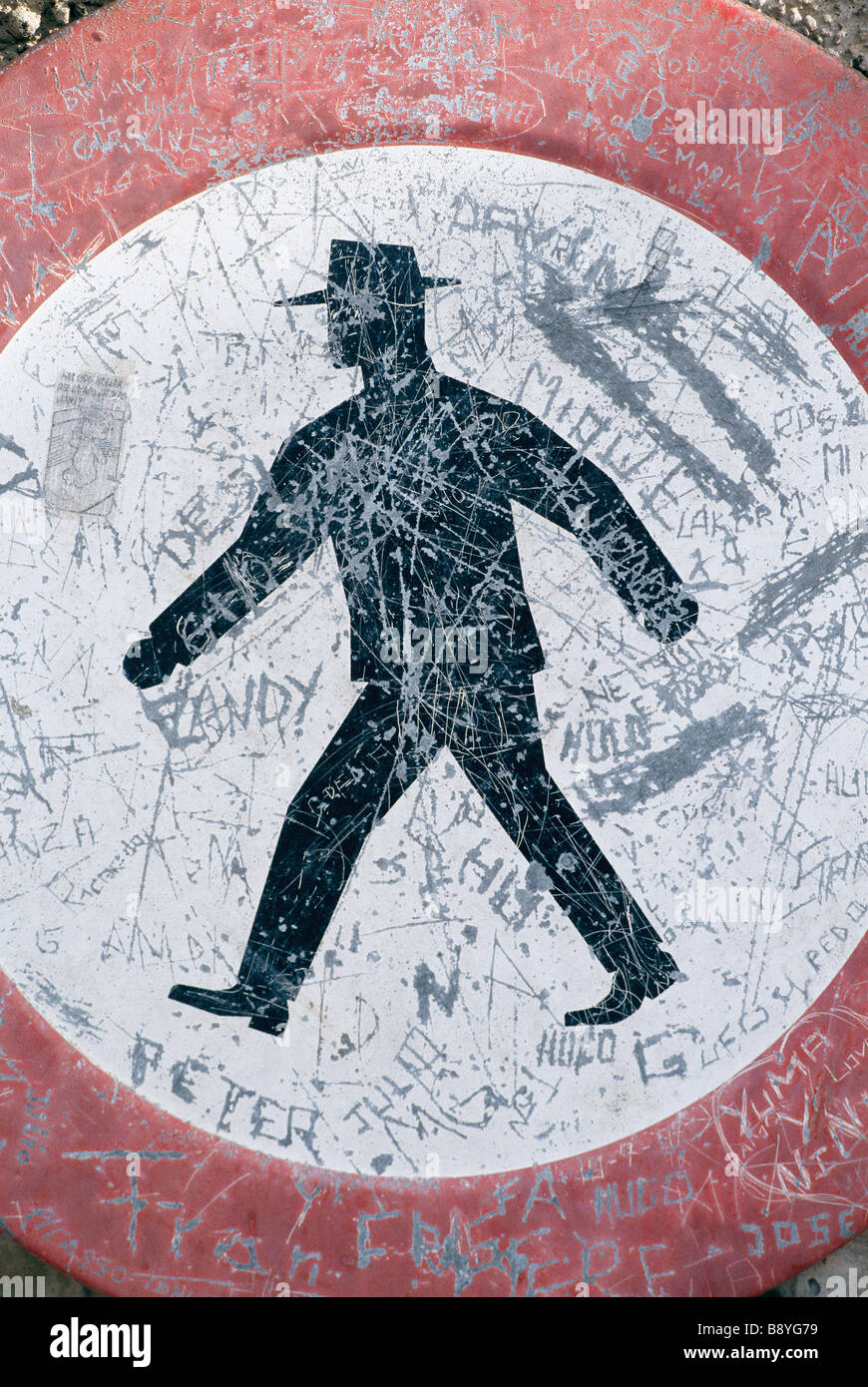 A sign of a walking man wearing a hat Stock Photo - Alamy