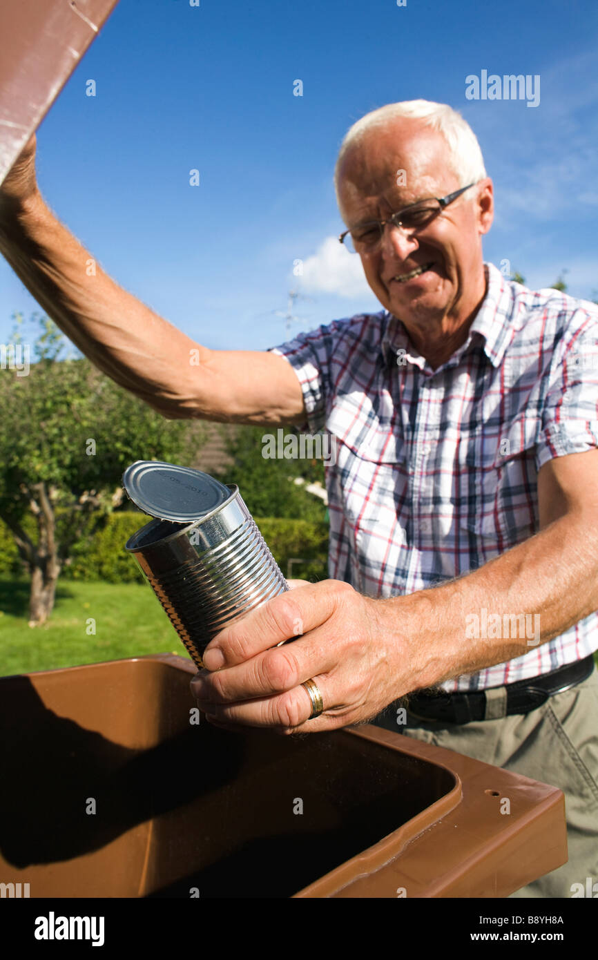 An elderly man holding a tin by a dustbin Sweden Stock Photo - Alamy
