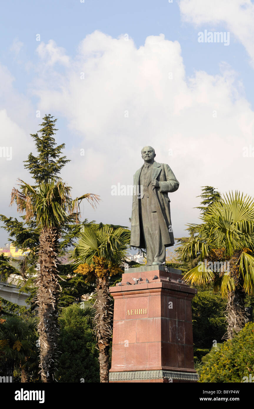 A bronze statue of Russian revolutionary Lenin stands among palm trees ...