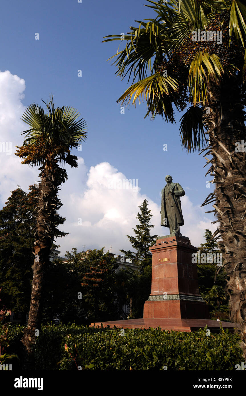 A bronze statue of Russian revolutionary Lenin stands among palm trees ...