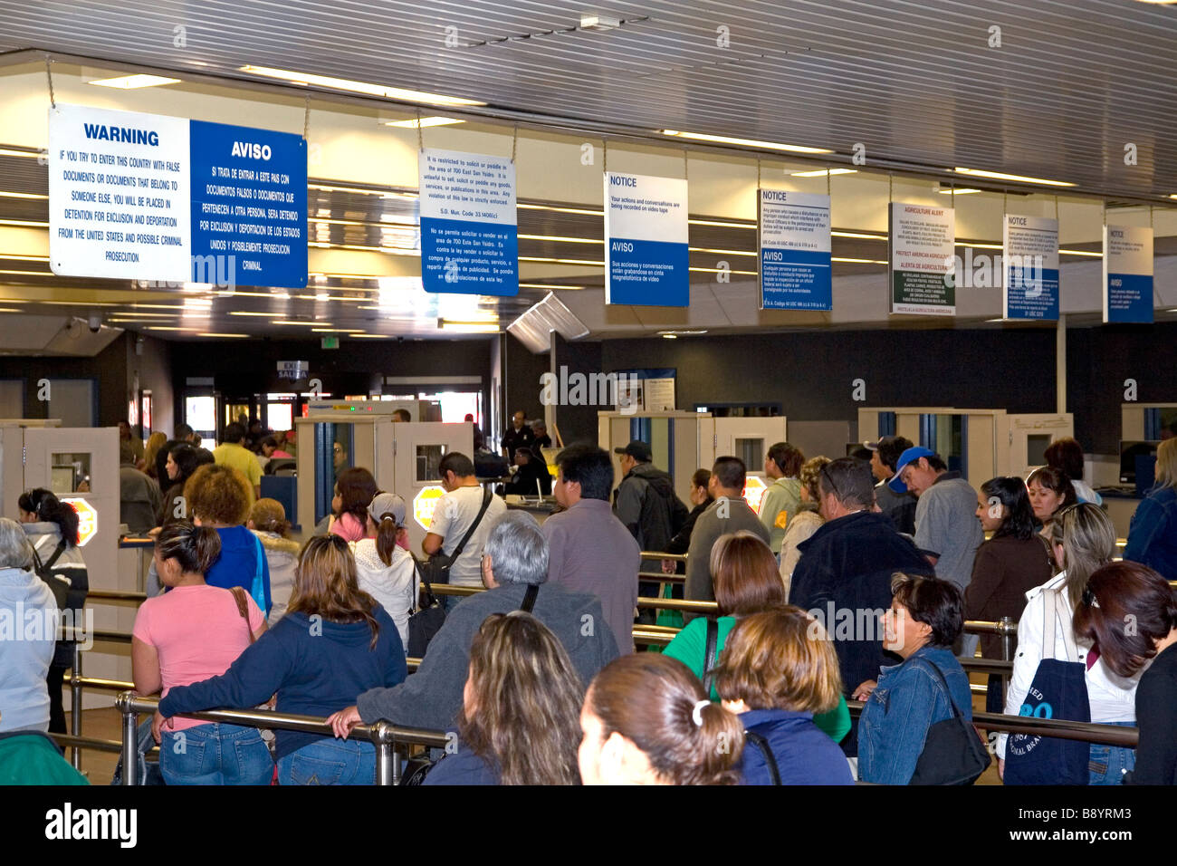 Immigrants wait in line to enter the U S port of entry at the Tijuana ...