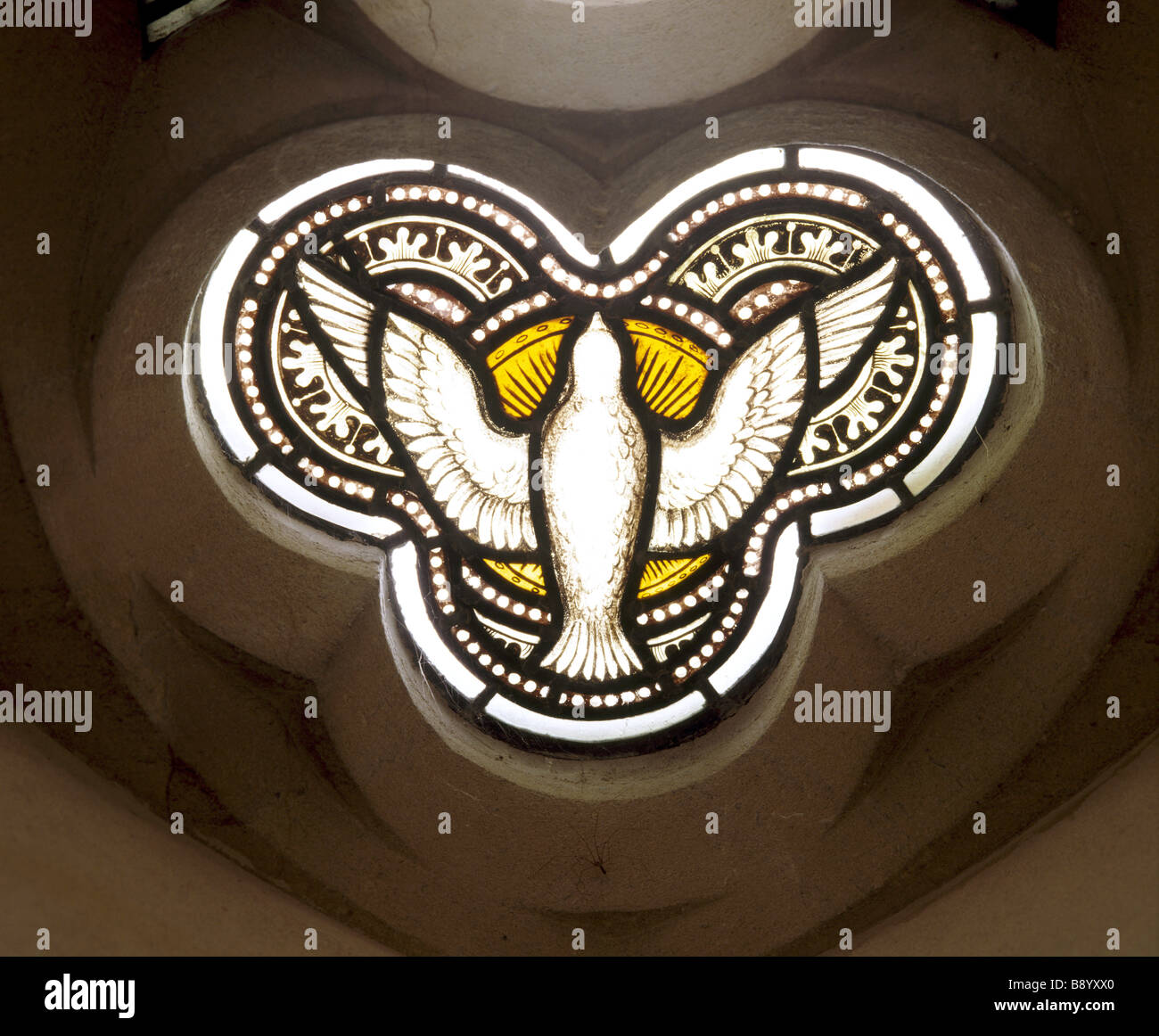 Close view of trefoil shaped stained glass window depicting a dove in ...