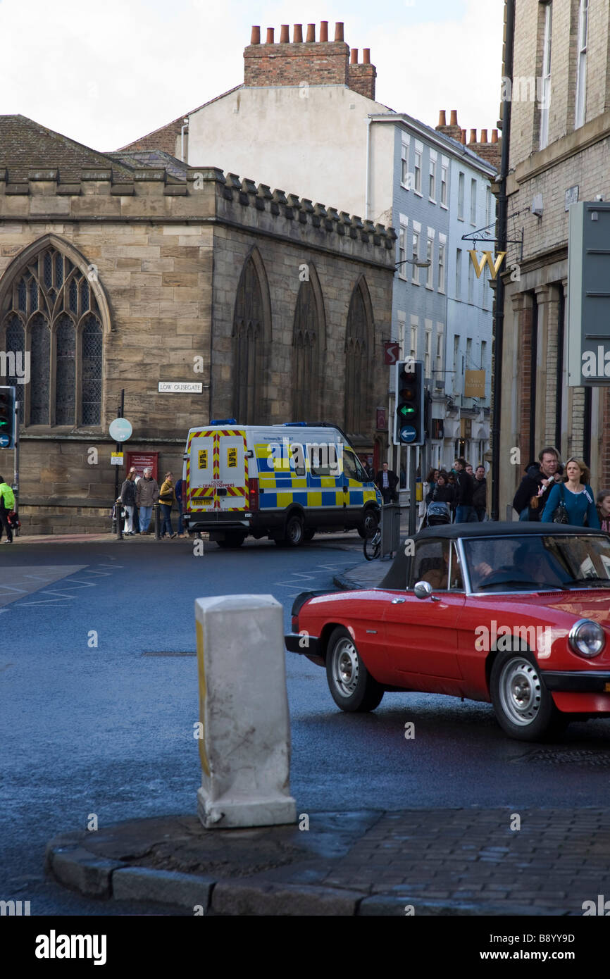 Ambulance rushes to an accident in a street scene in York UK England ...