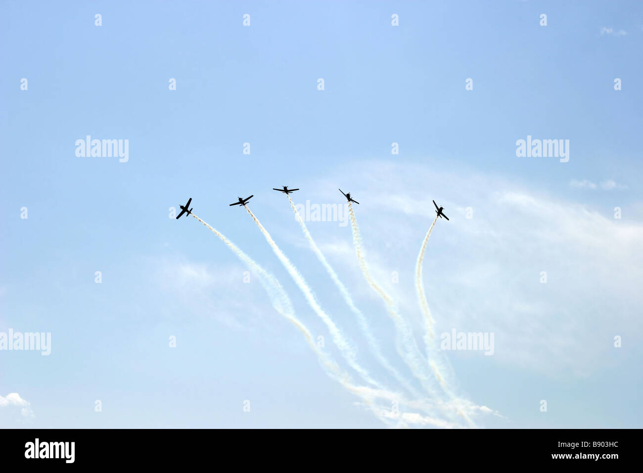 five airplanes breaking formation trailing smoke Stock Photo - Alamy