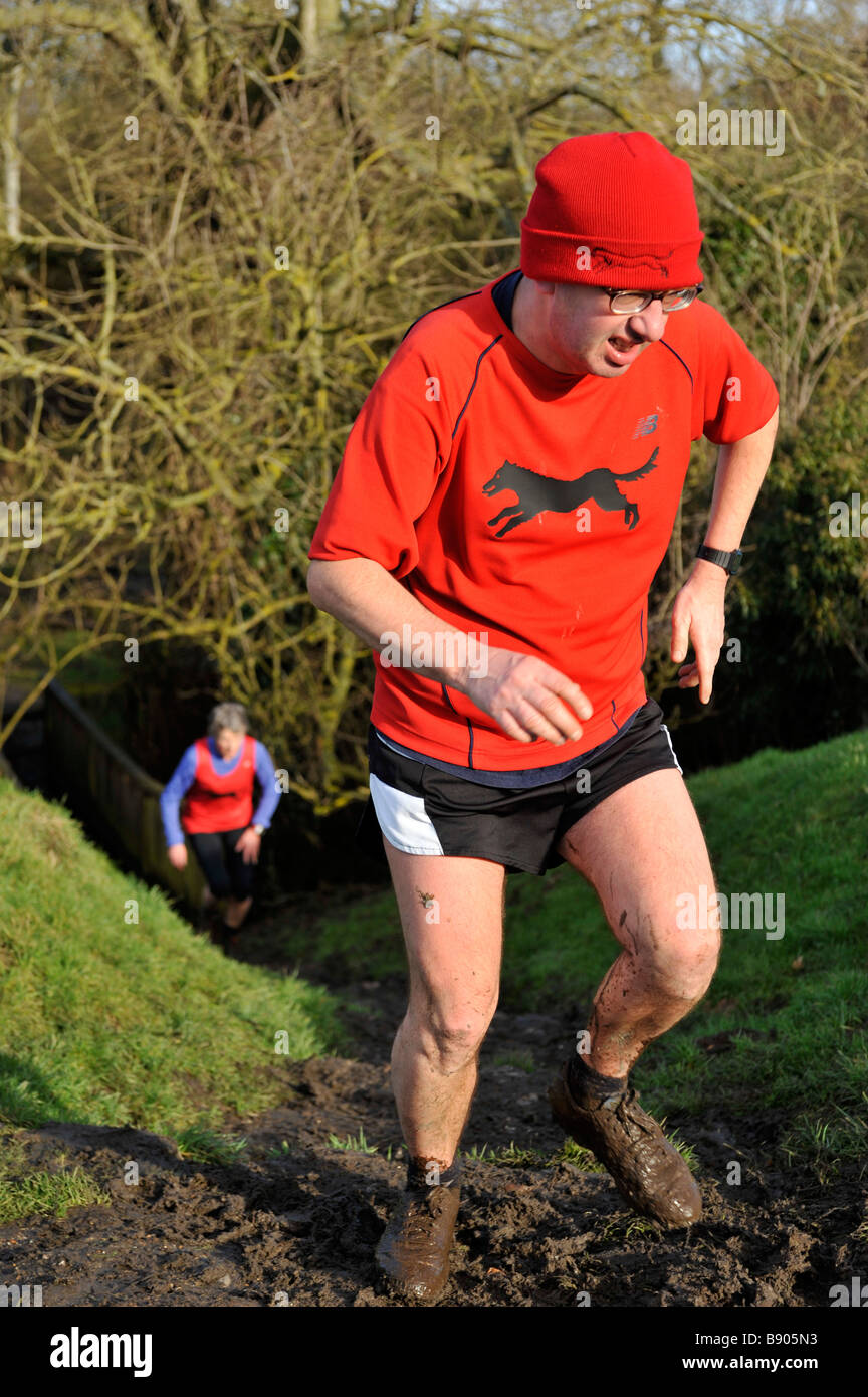man running in mud in inter club cross country race at framlingham ...
