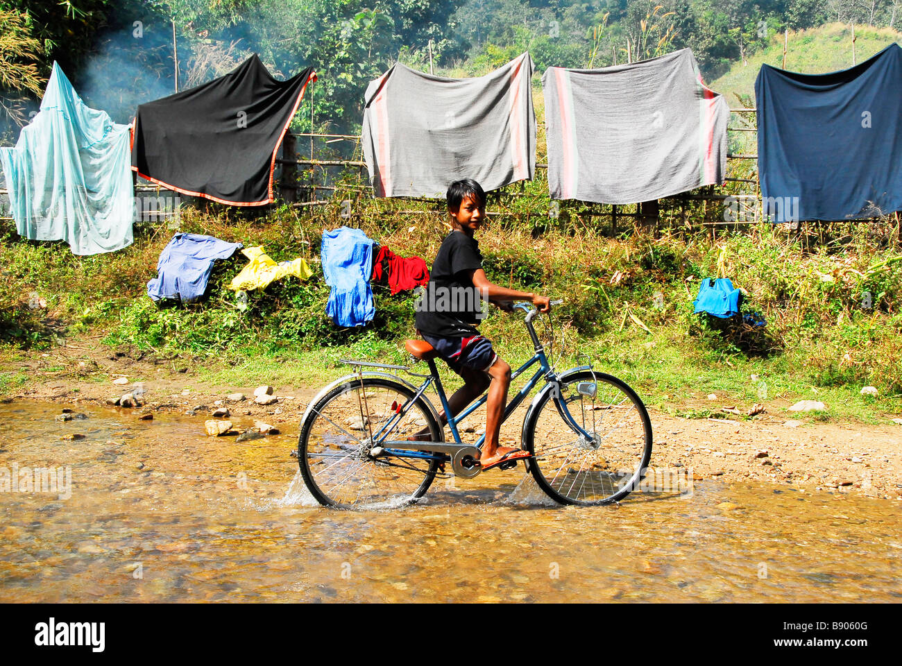 Refugee people drying thier clothes on the bamboo fence beside thr ...