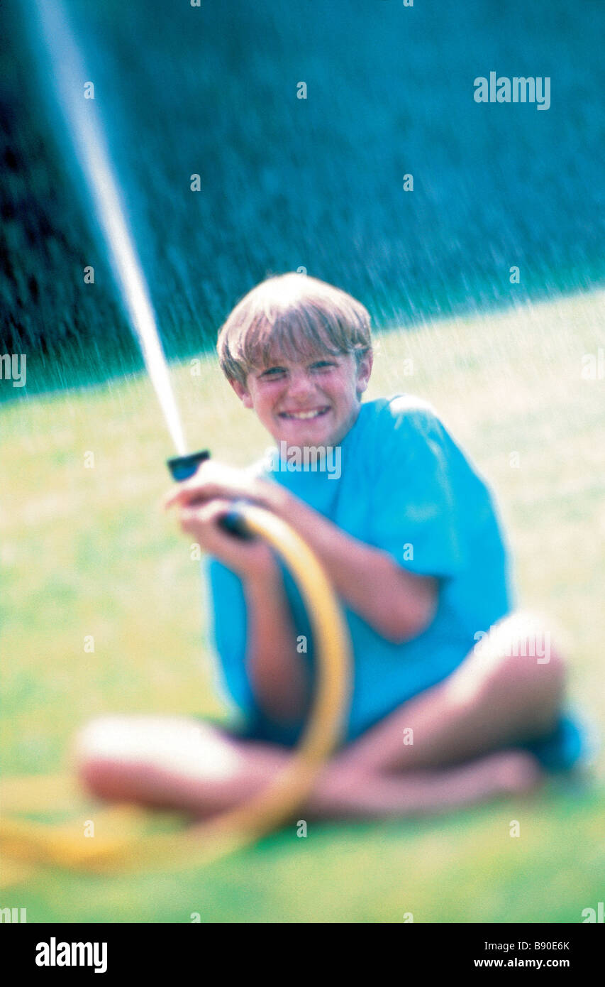 FL2559, TREVOR BONDERUD; Boy playing hose Stock Photo - Alamy