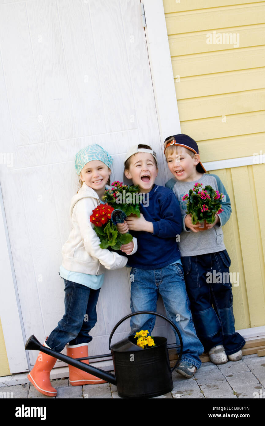 Three children with flowers Stock Photo - Alamy