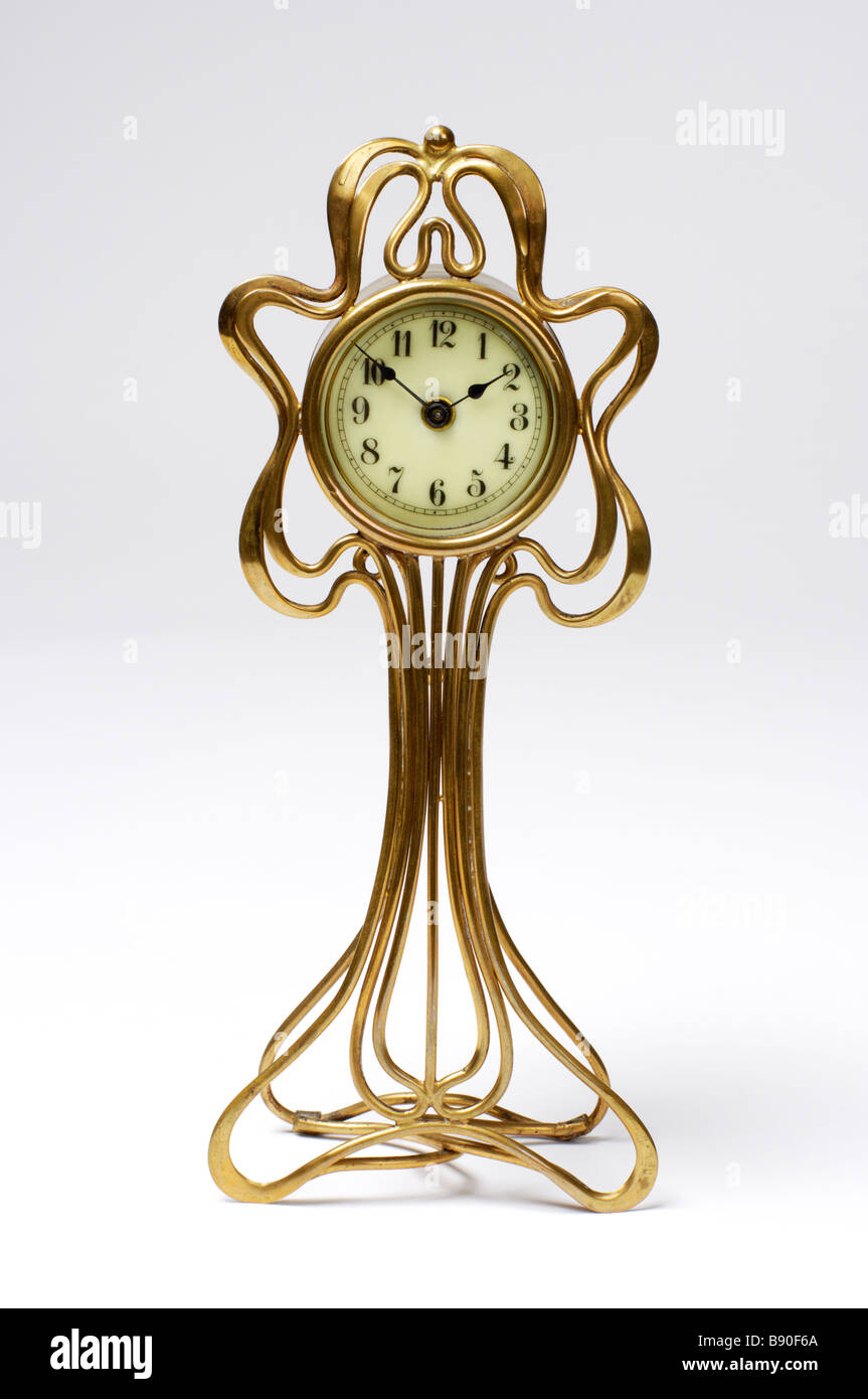 A French art nouveau table clock with brass case and enamelled dial ...