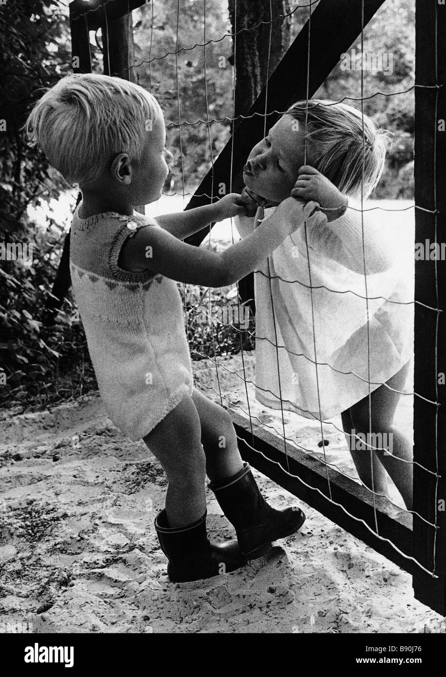 FL3172, Polfoto; Young girl giving boy kiss through fence Stock Photo ...