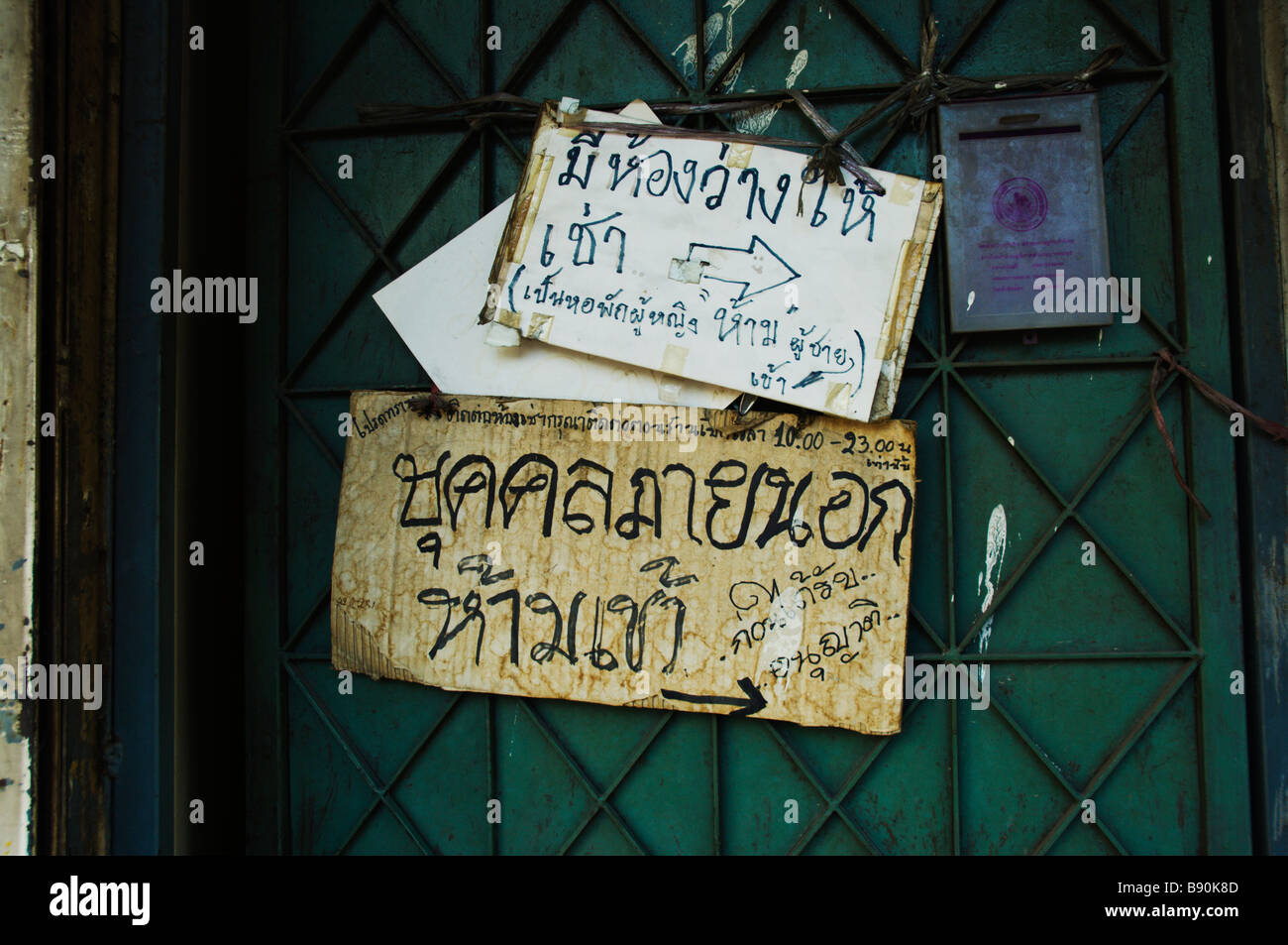 Sticky notes on old door reading in Thai "Room for rent Stock Photo - Alamy