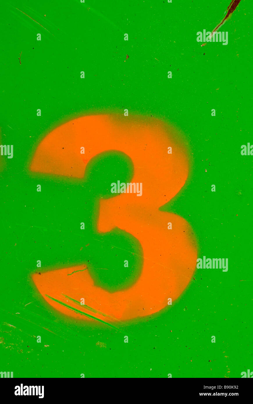 An orange number 3 stencilled on a green painted background Stock Photo ...