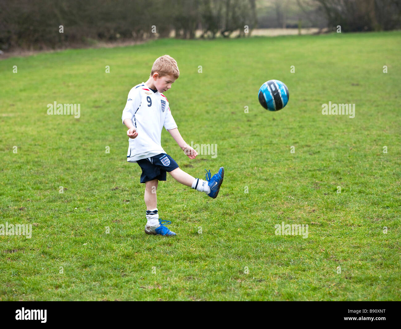 young boy playing football soccer on a pitch Stock Photo - Alamy