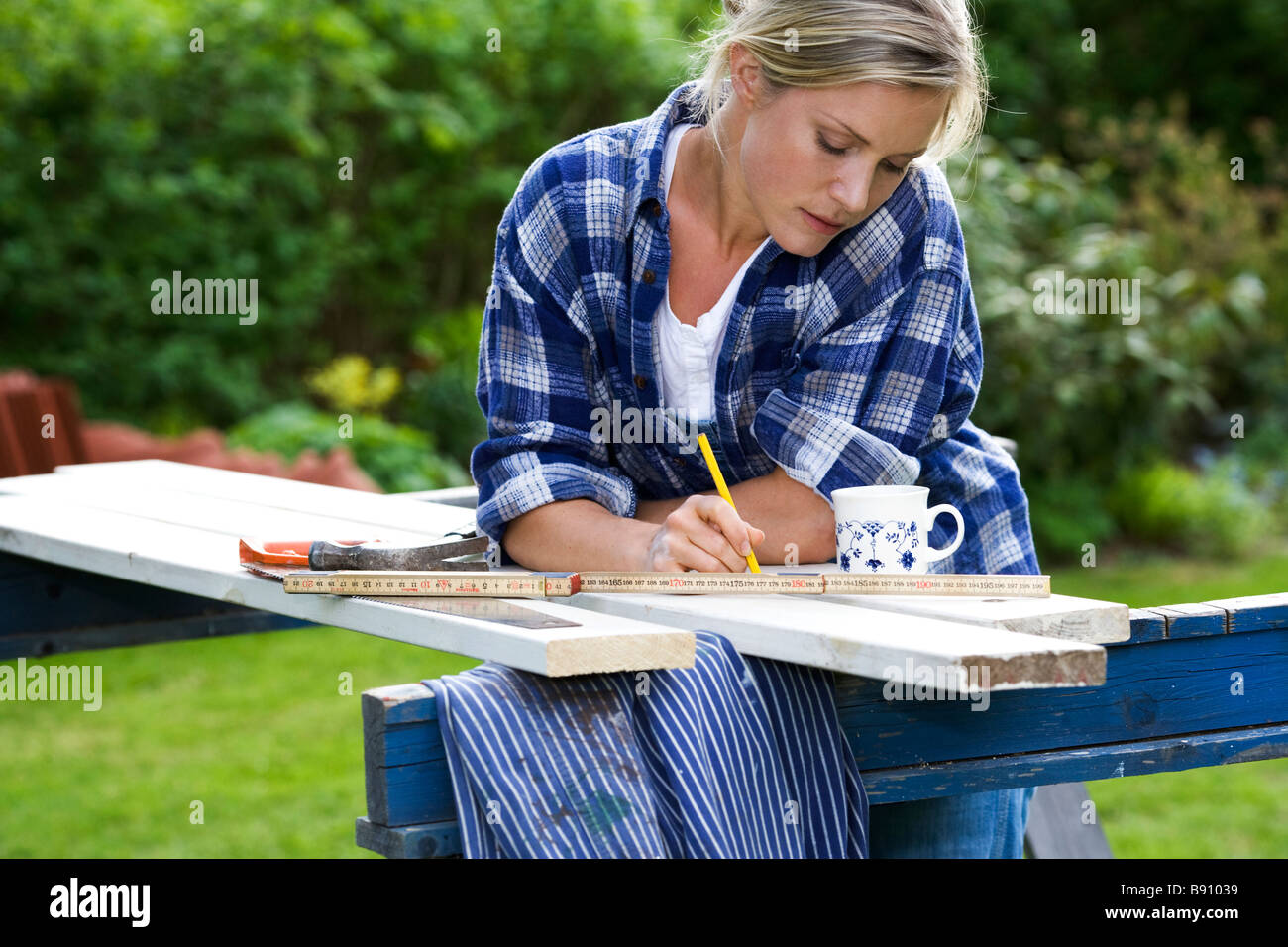 A woman doing carpentry in a garden Sweden Stock Photo - Alamy